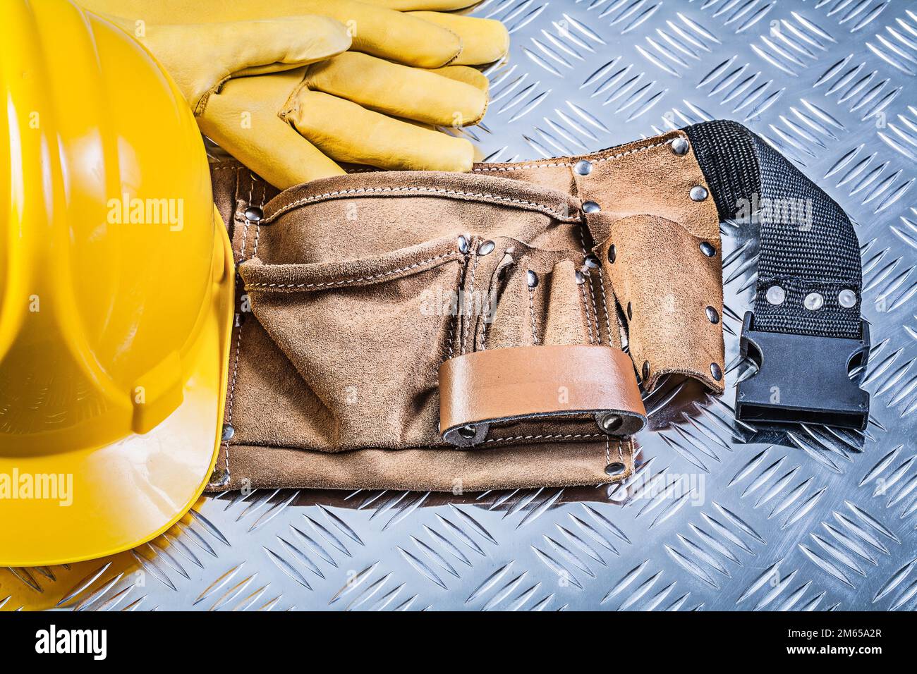 Leather building belt safety gloves hard hat on grooved metal plate ...