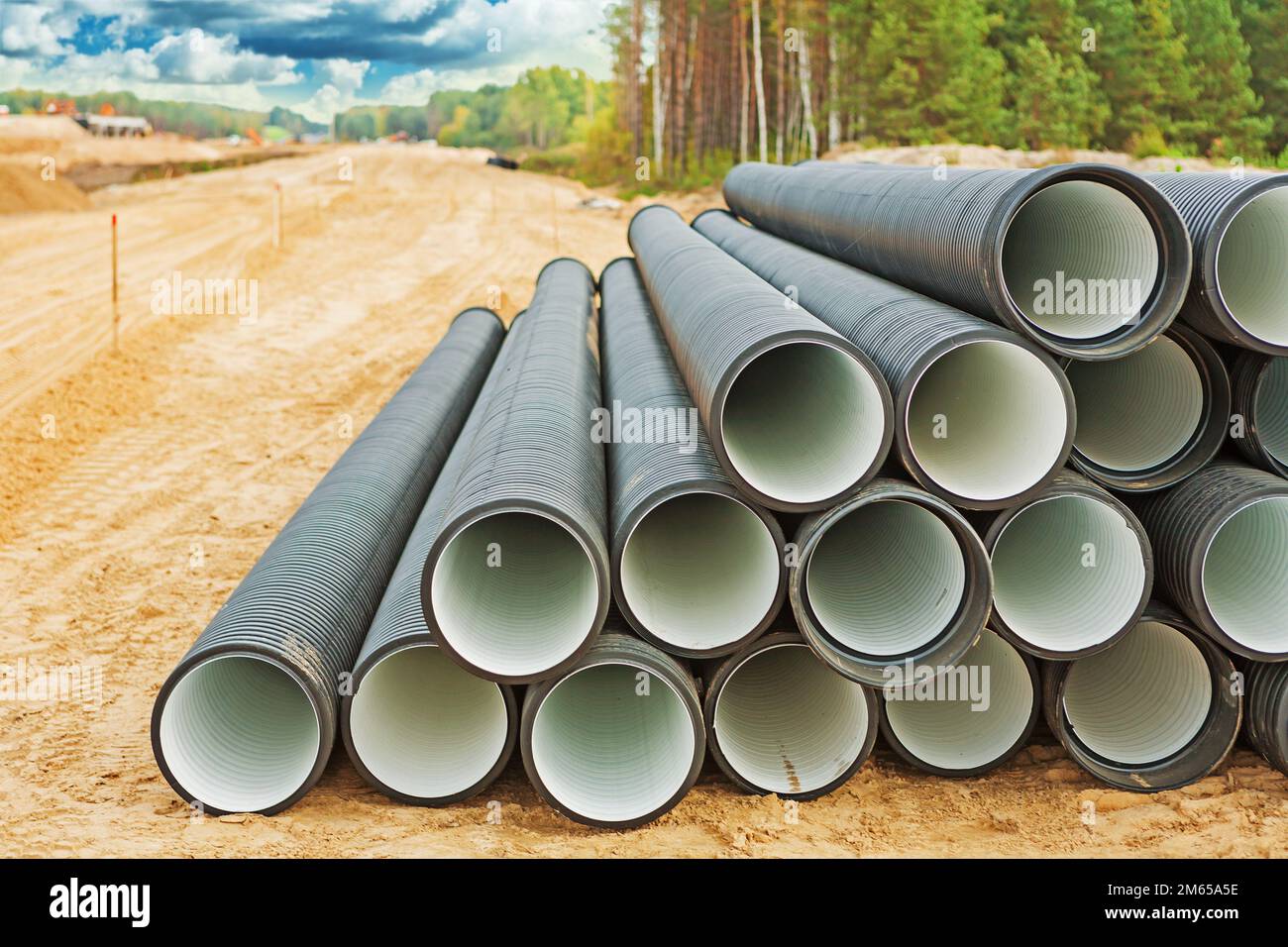 pile of big water pipes on construction site Stock Photo - Alamy