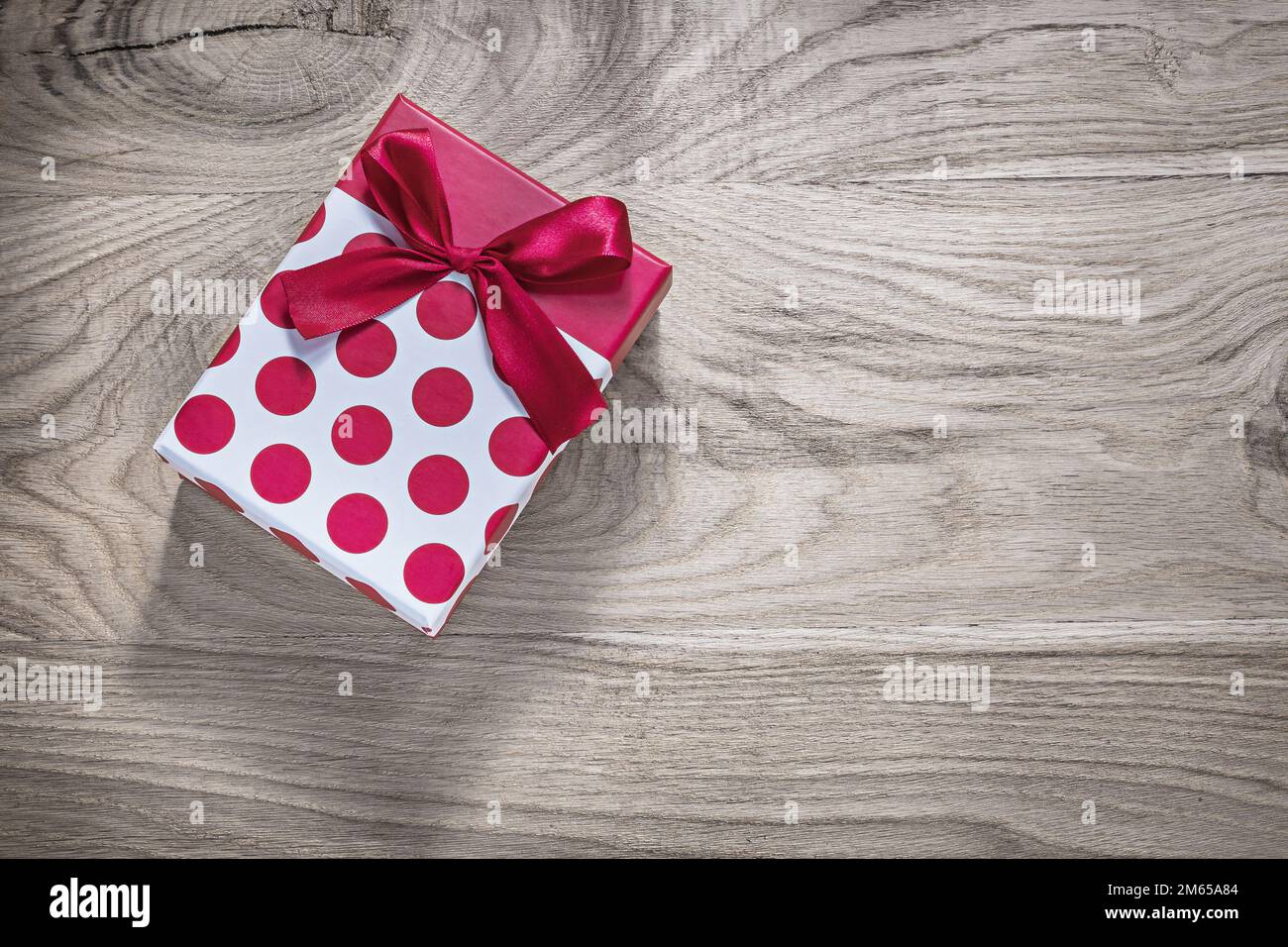 Red gift box with bow on wooden board holidays concept Stock Photo - Alamy