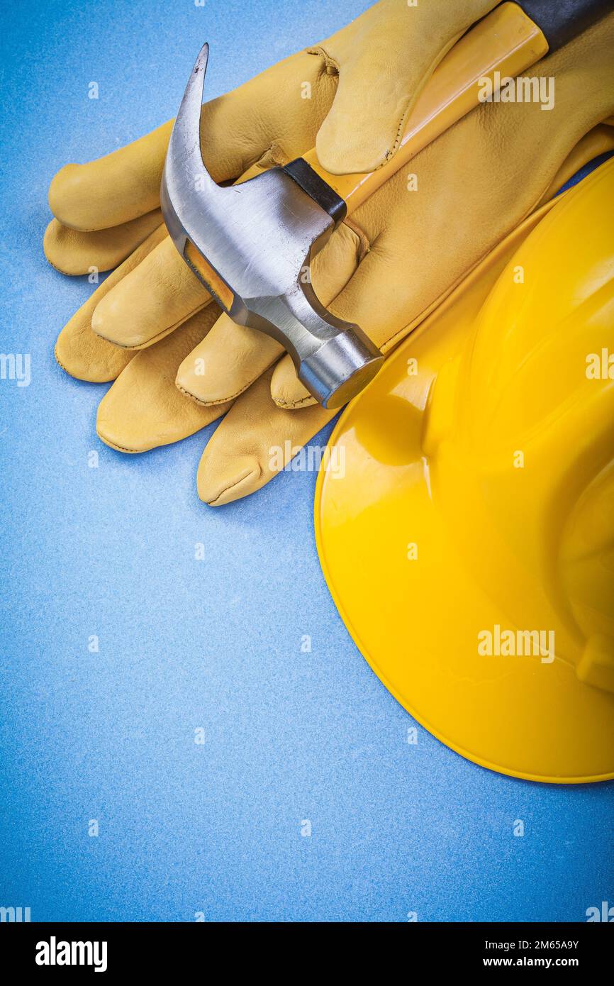 Set of claw hammer safety gloves building helmet on blue background ...