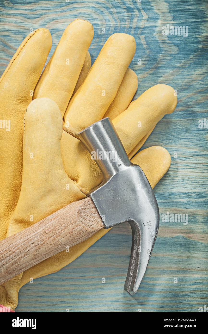 Set of claw hammer protective gloves on wooden board construction ...