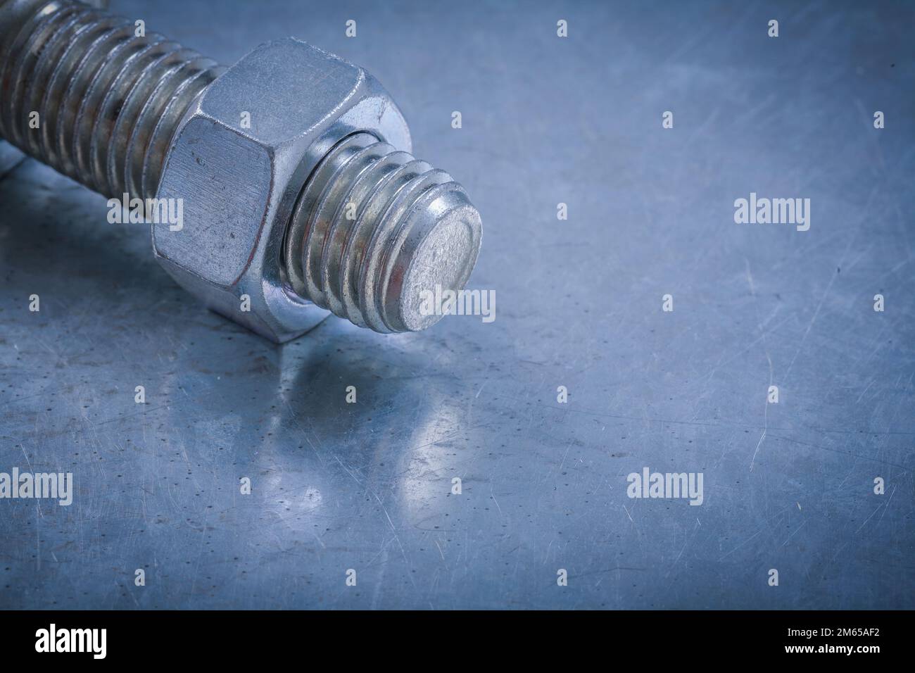 Threaded bolt detail and nut on metallic background construction ...