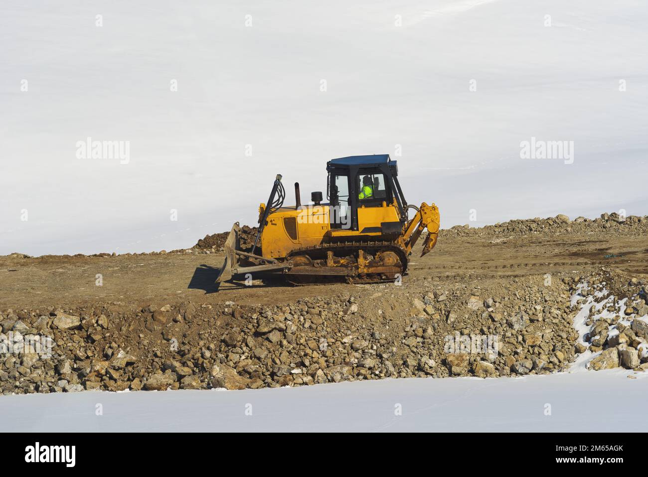 Unrecognizable worker driving industrial bulldozer heavy-duty machinery ...