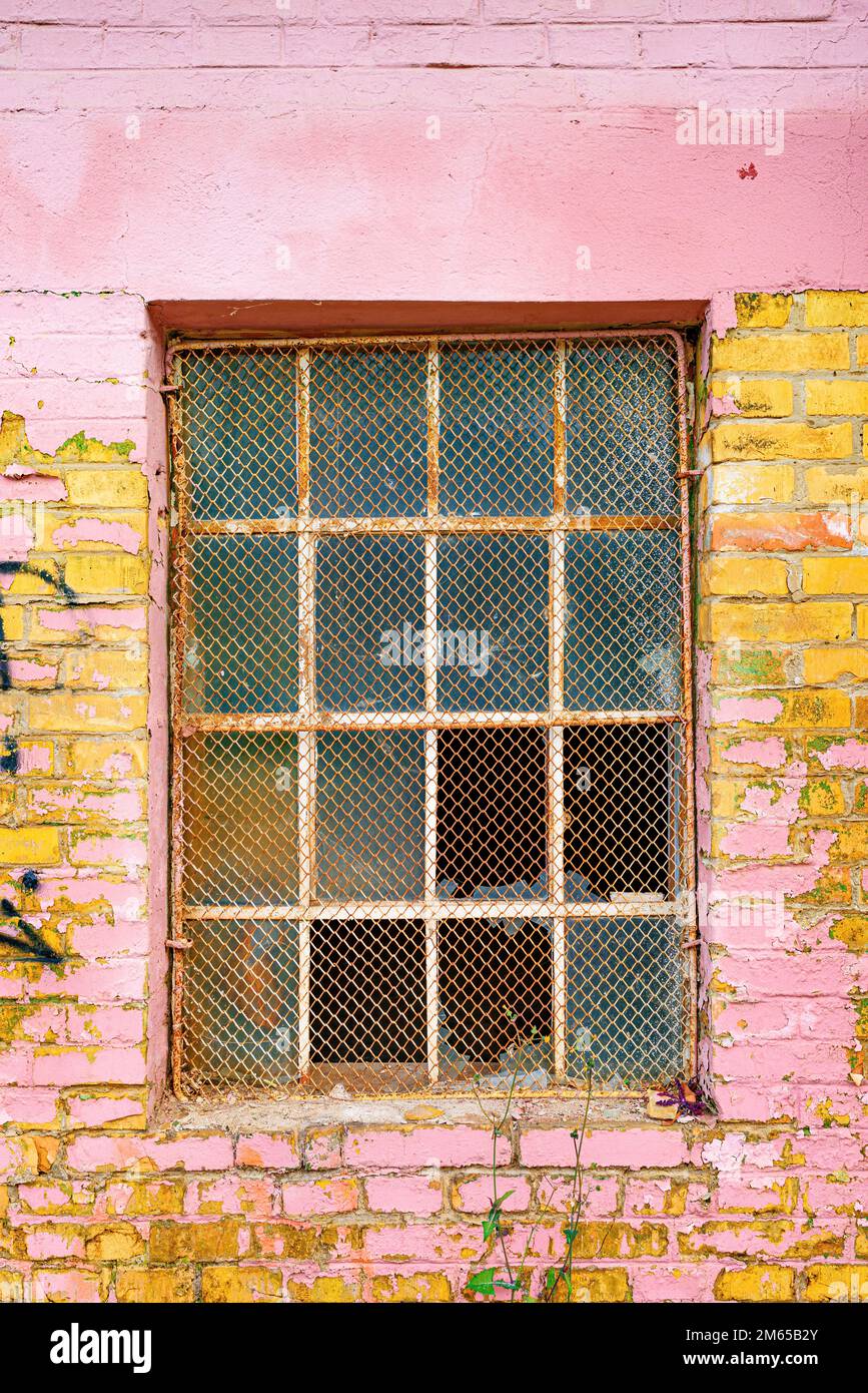 Old grid windows with broken glass on exterior wall of an old abandoned ...