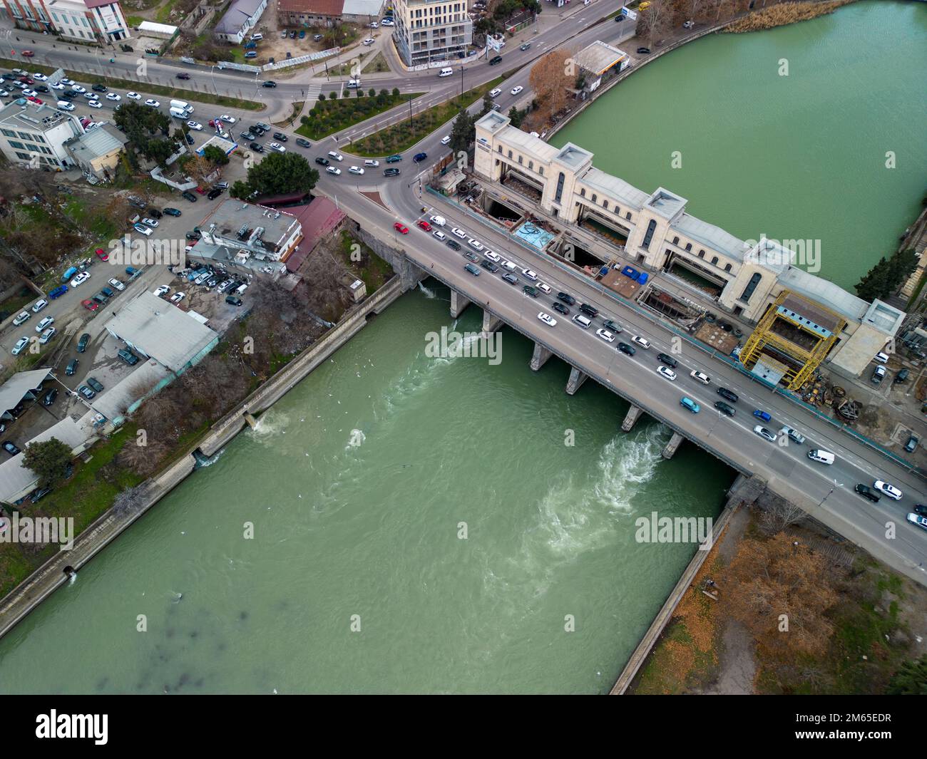 An aerial view of Tbilisi cityscape houses and a bridge on a river in ...