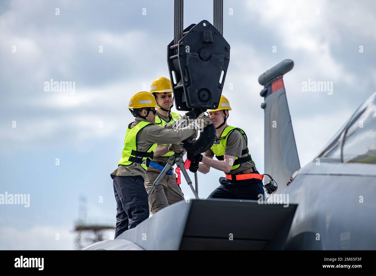 Airmen assigned to the 18th Equipment Maintenance Squadron hook anchor ...