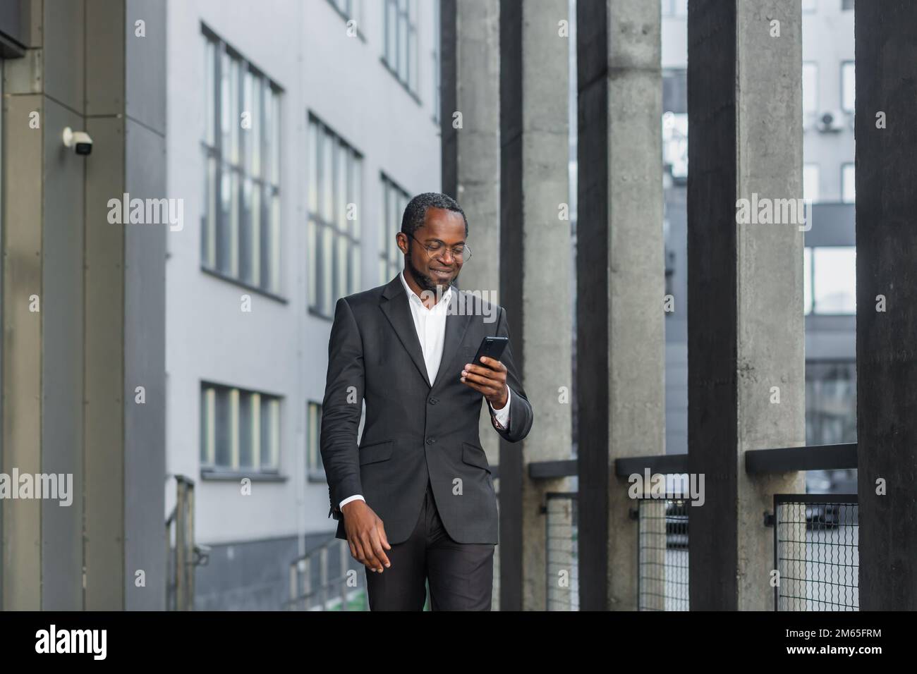Happy successful African American businessman boss walking outside ...