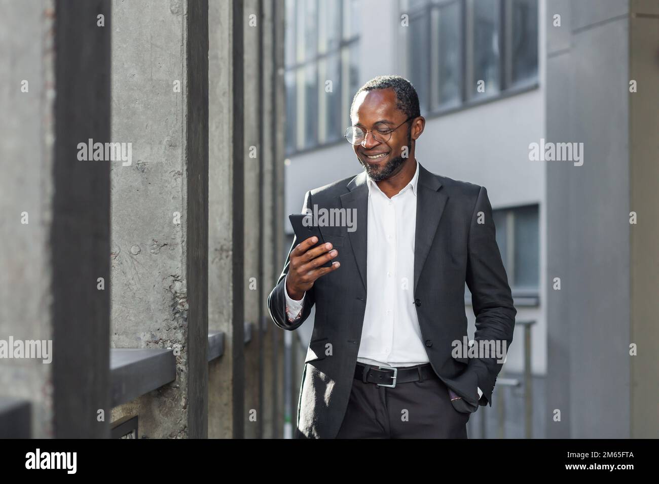 Happy successful African American businessman boss walking outside ...