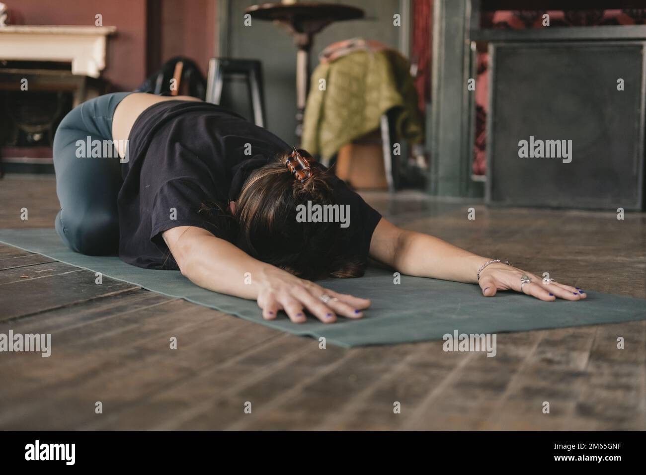 Full-body photo of female yogi resting in child pose (Balasana) with ...