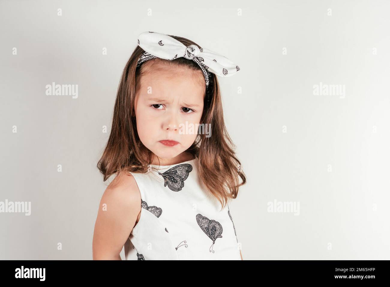 Unhappy little girl with offended facial expression. Portrait of ...