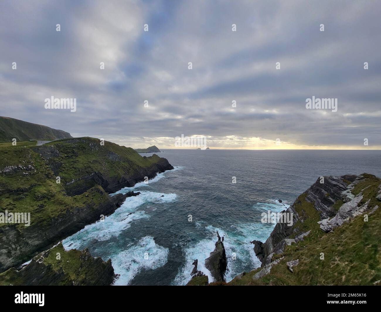 A scenic landscape with green fields and a sea shore during daytime ...