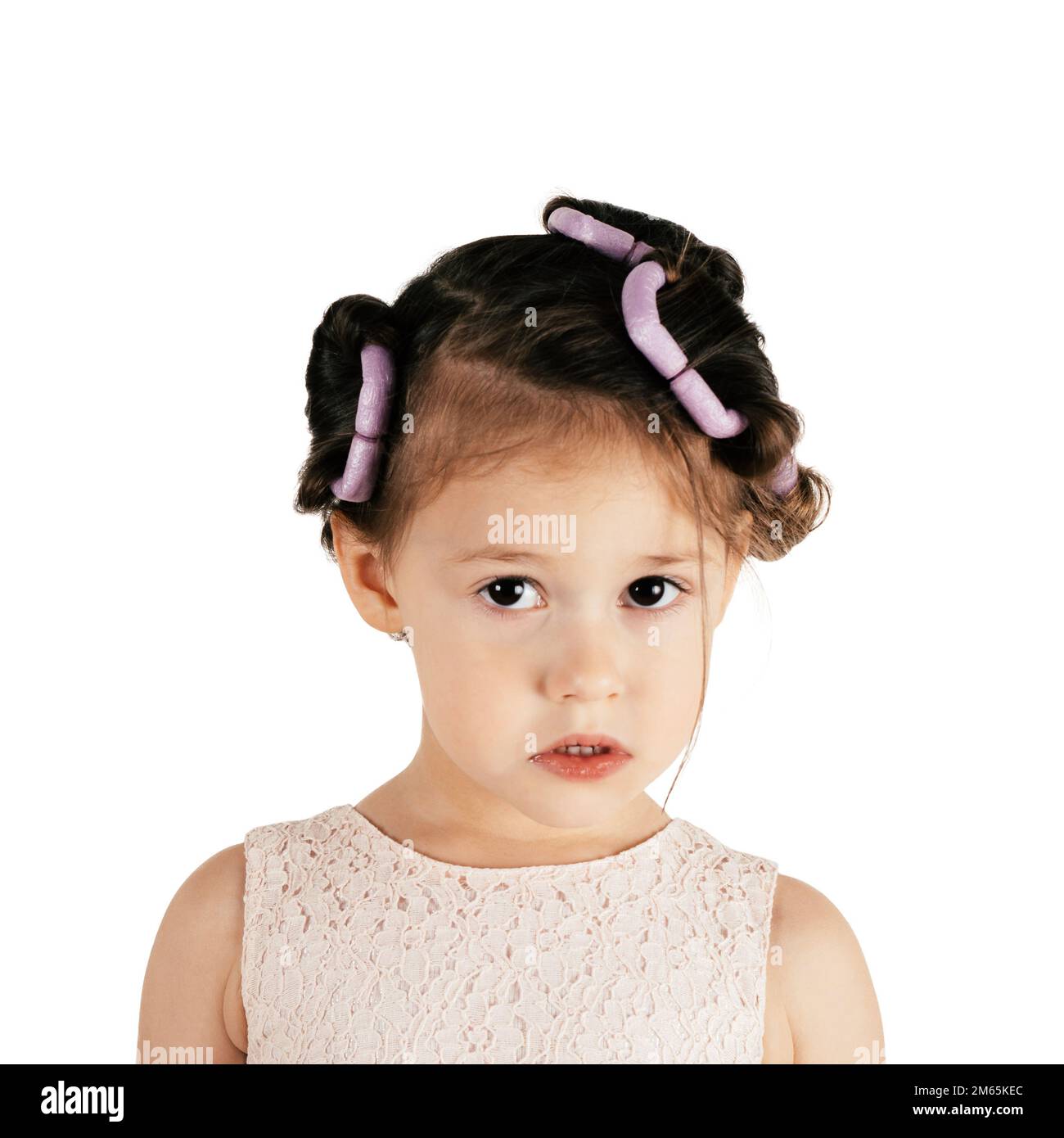 Discontent little girl with hair curlers. Portrait of child isolated on ...