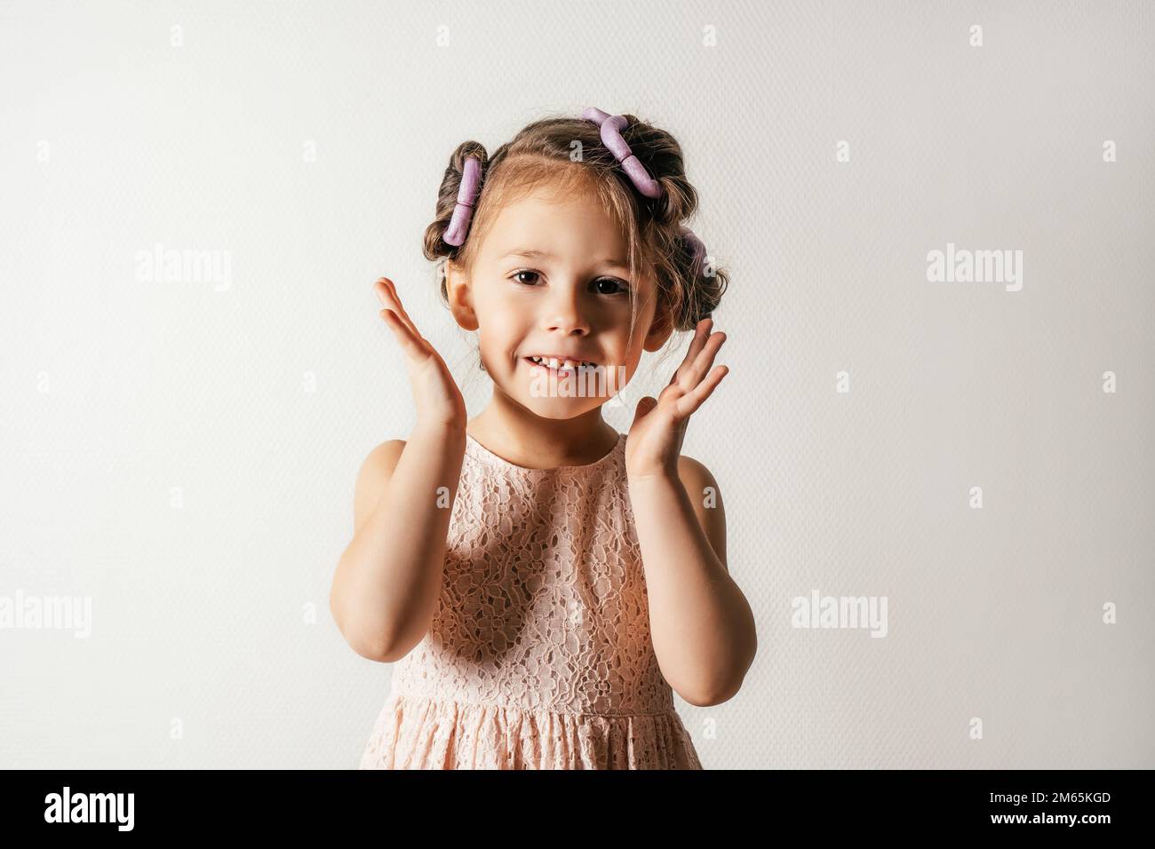 Joyful little girl with hair curlers. Portrait of smiling child on ...