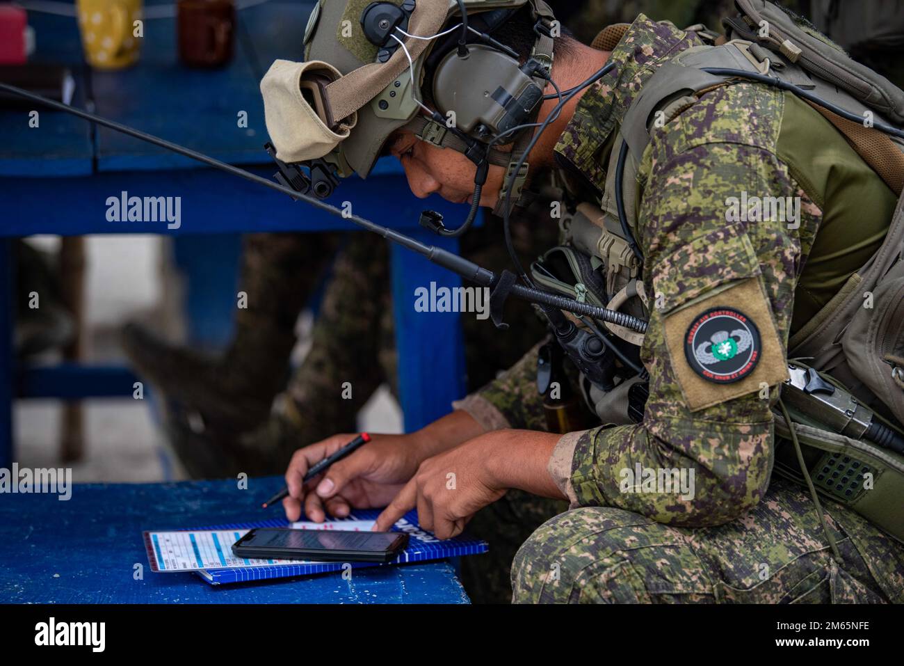 A Philippine Air Force combat air controller checks his forward air ...