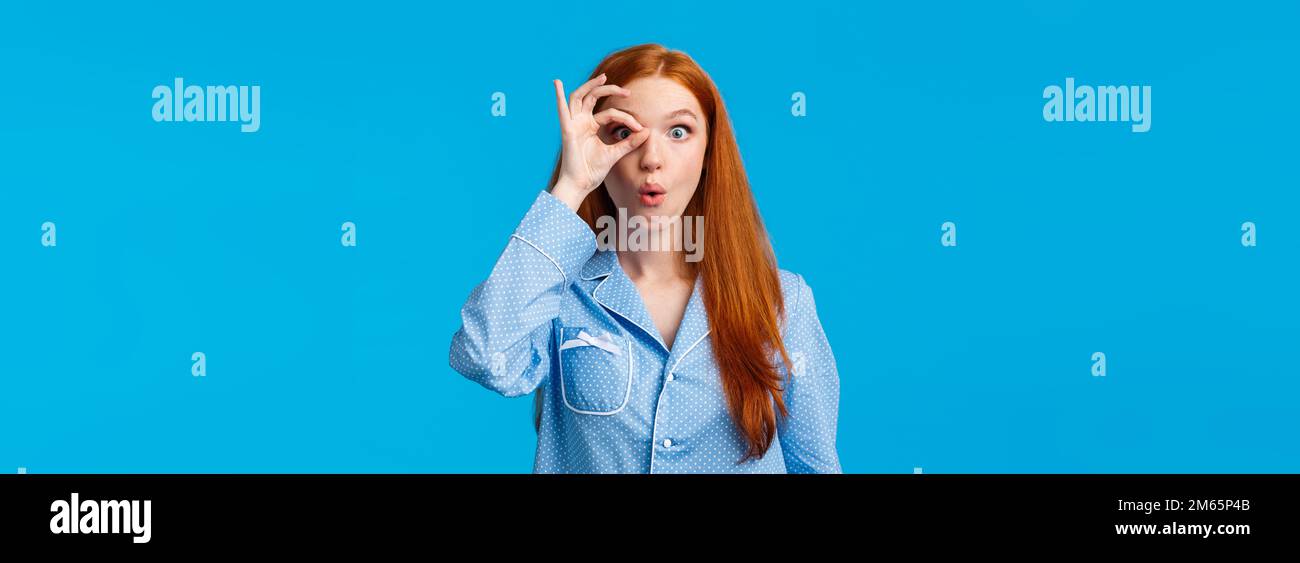 Wow amazing. Impressed and surprised curious redhead woman staring at ...