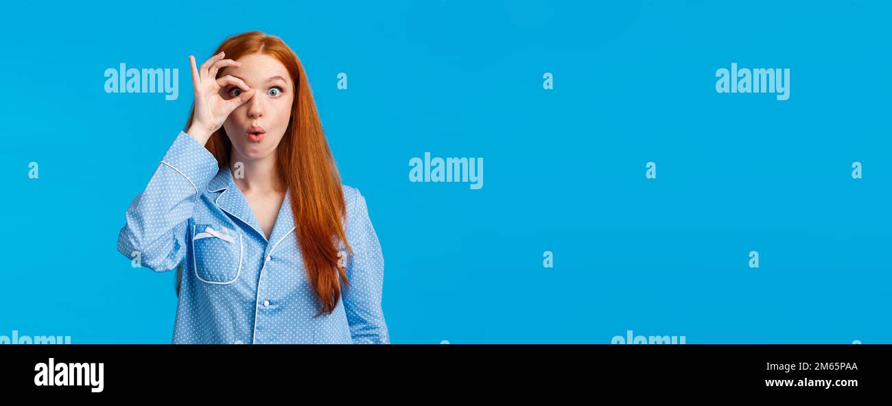 Wow amazing. Impressed and surprised curious redhead woman staring at ...