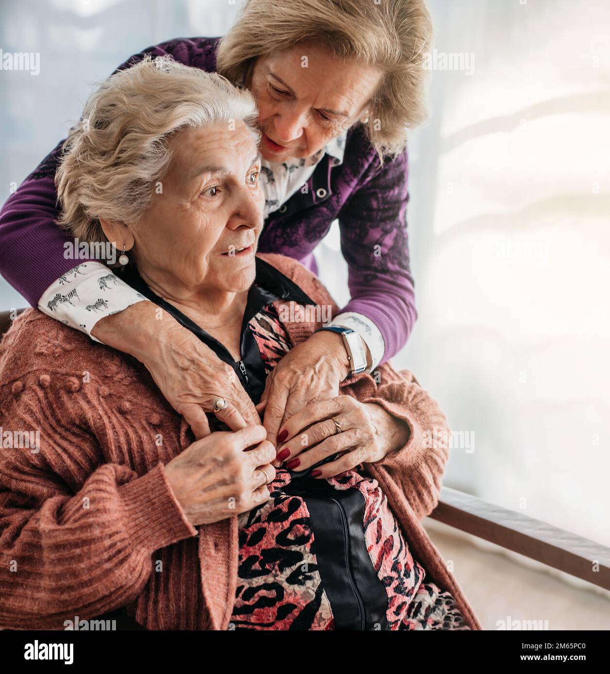 a woman hugs her elderly sister in a nursing home. concept of family ...
