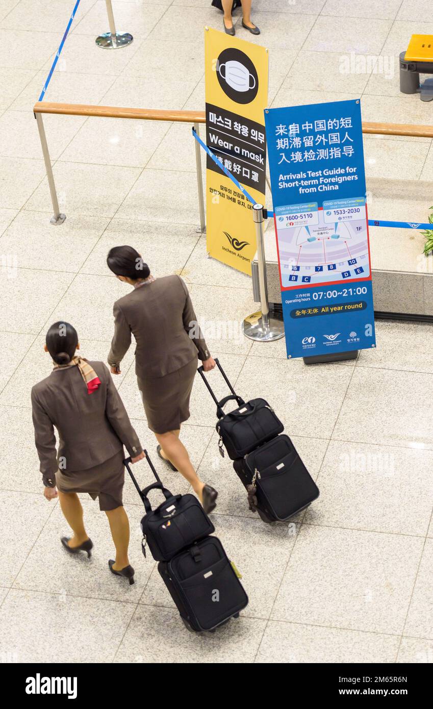 Airline employees pass the information board of the COVID-19 inspection ...