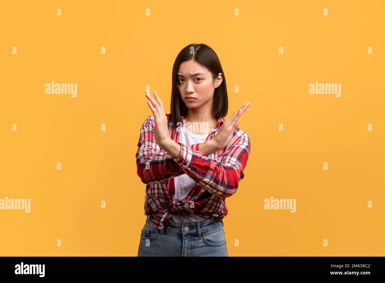 Portrait of assertive asian lady showing STOP or ENOUGH gesture ...
