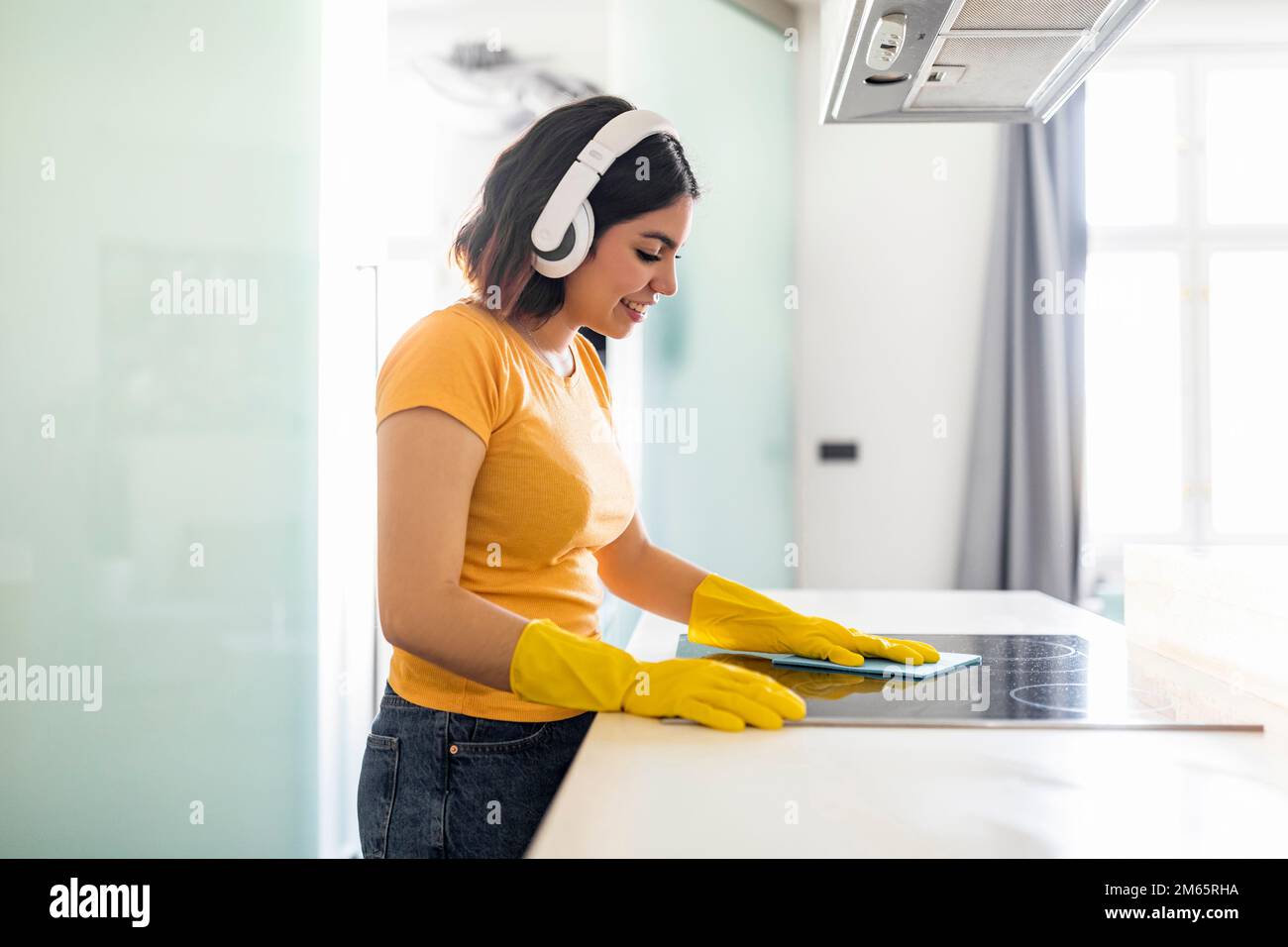Smiling Middle Eastern Housewife Washing Table In Kitchen With Rag ...