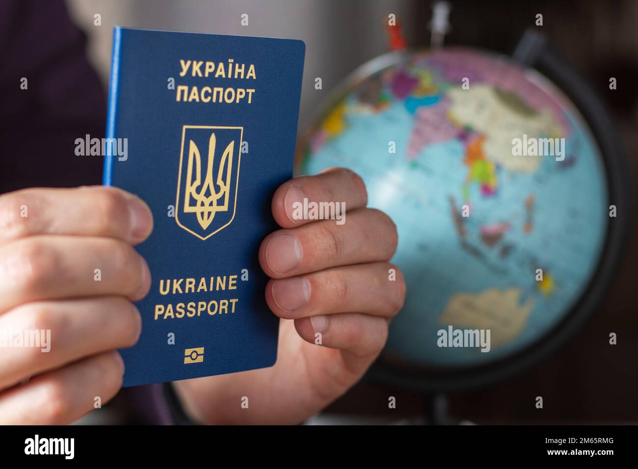 Ukraine, passport. Ukrainian passports in hands are on the world map ...