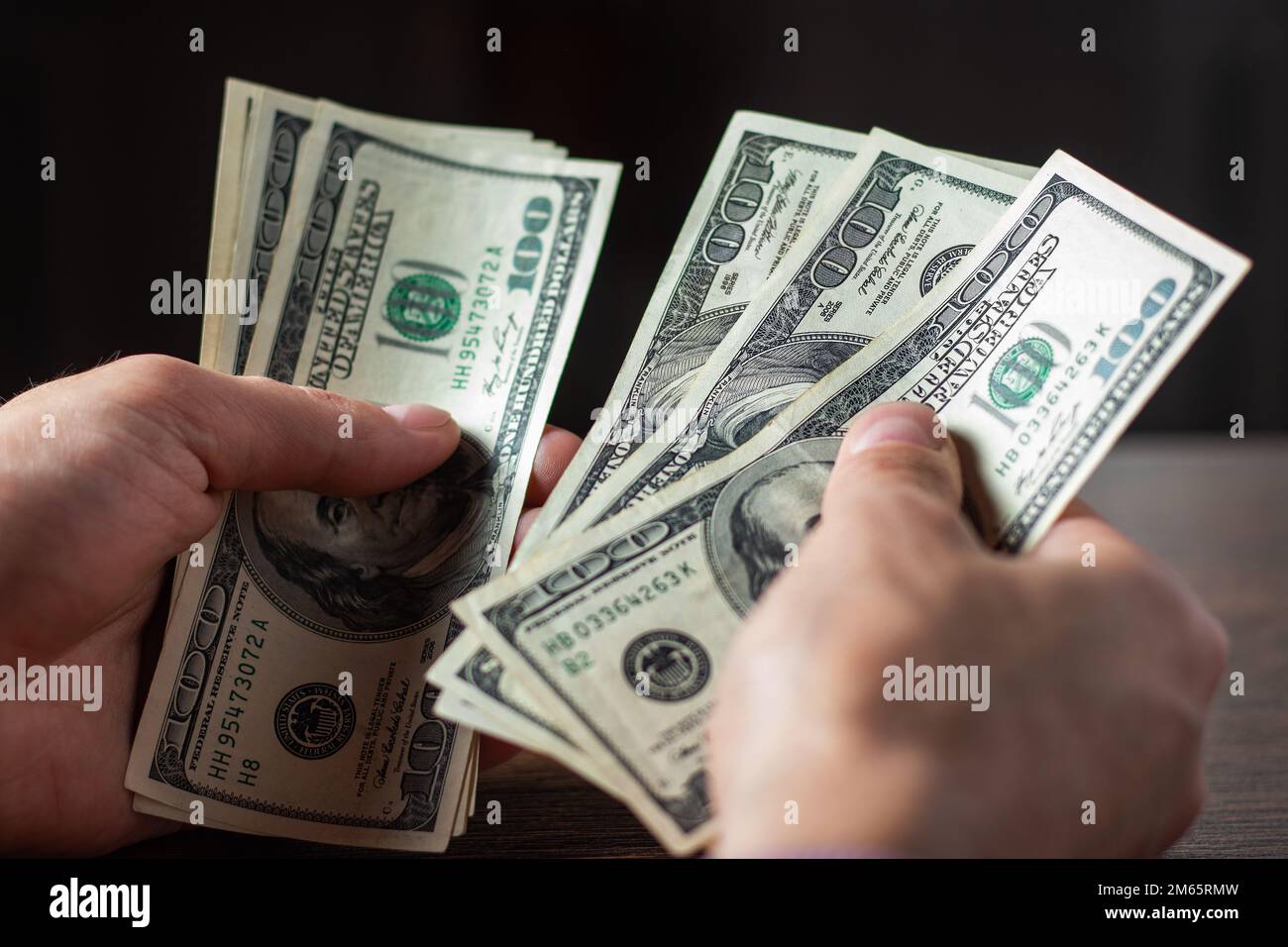 a man holds stack hundred-dollar bills in his hands close-up Stock Photo - Alamy