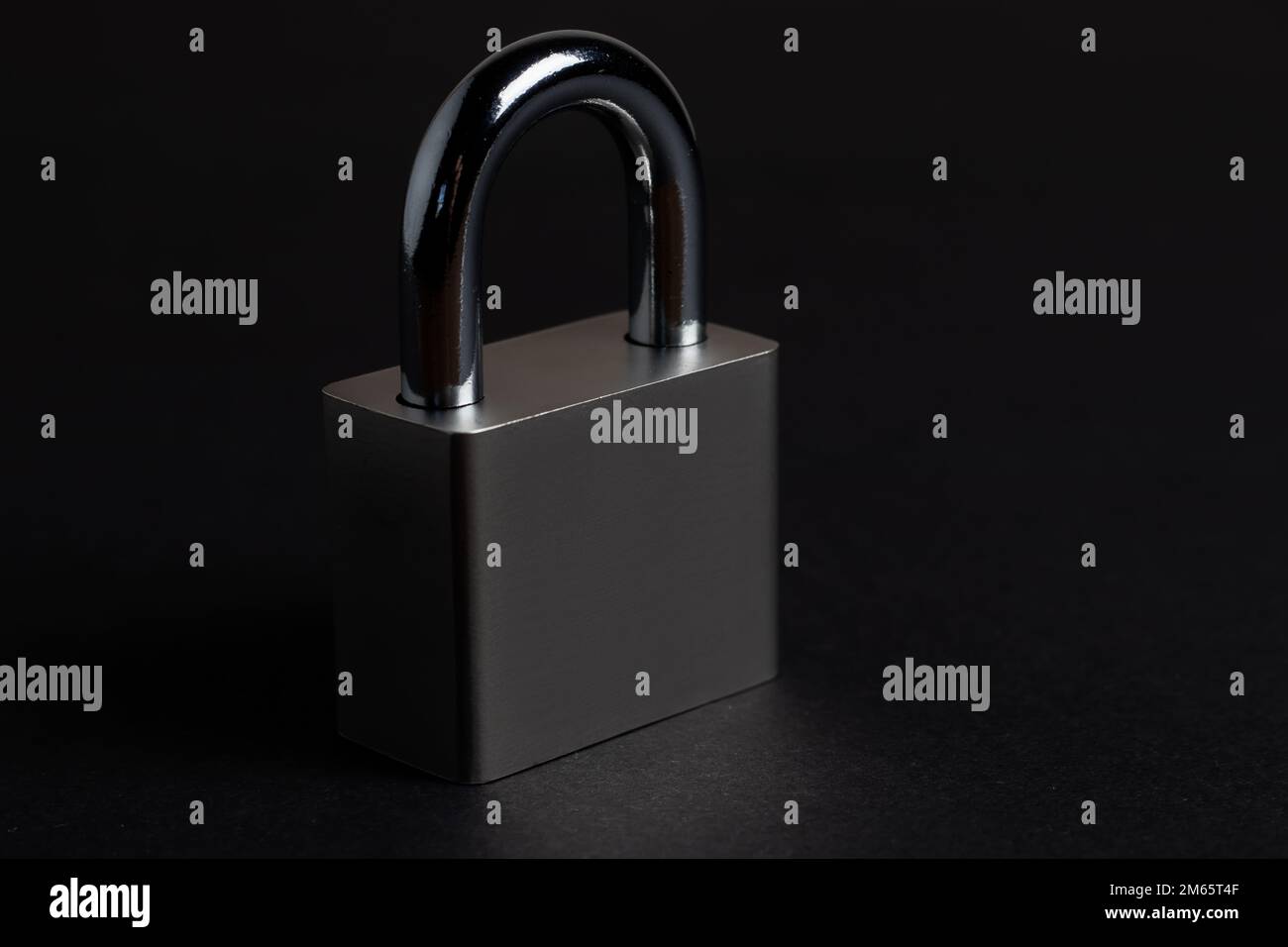 Steel padlock on the black textured background Stock Photo - Alamy