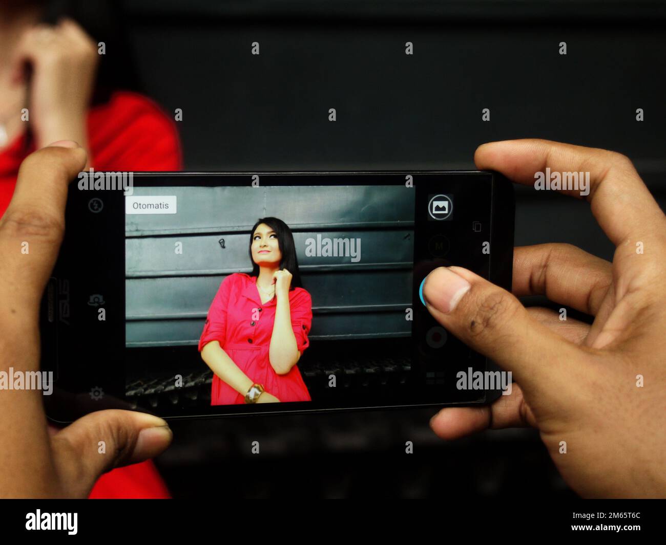 a photographer is photographing an Indonesian female model. The female ...