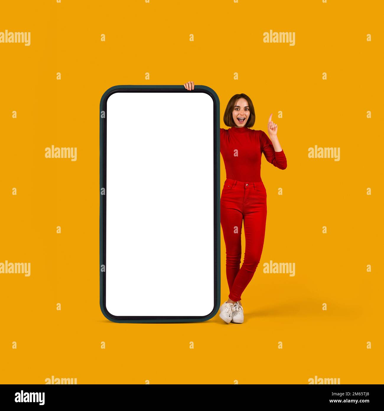 Excited pretty young woman posing by huge cell phone, mockup Stock ...