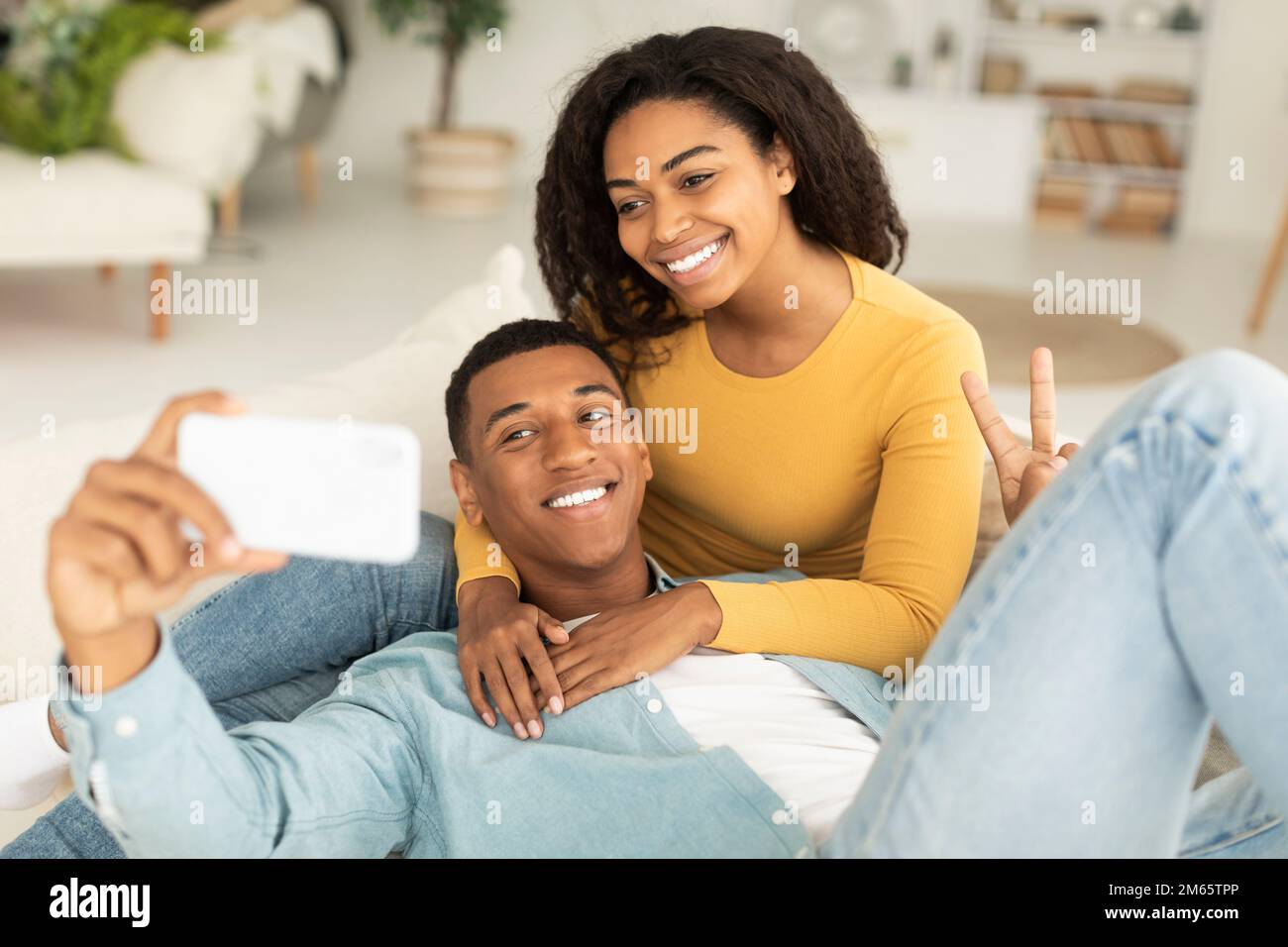 Smiling Millennial African American Wife Hugging Husband Relaxing On