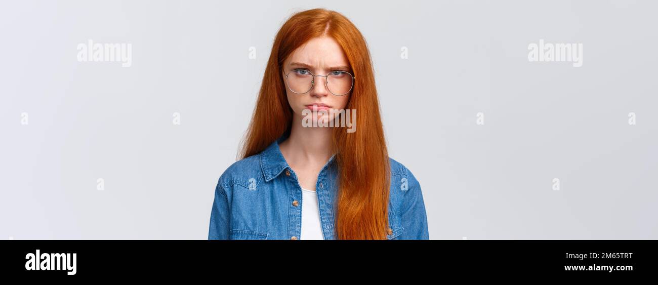 Close-up portrait strict and angry, mad gloomy redhead girl staring ...