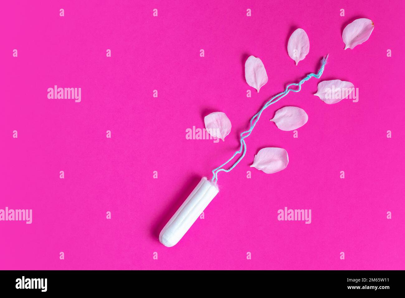 Female tampon with with cherry petals on a pink background. Hygienic ... Female tampon with with cherry petals on a pink background. Hygienic ...