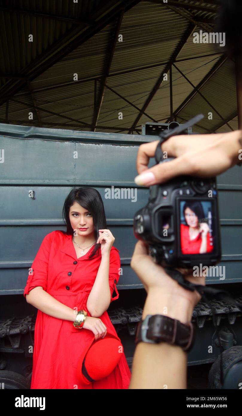 a photographer is photographing an Indonesian female model. The female ...
