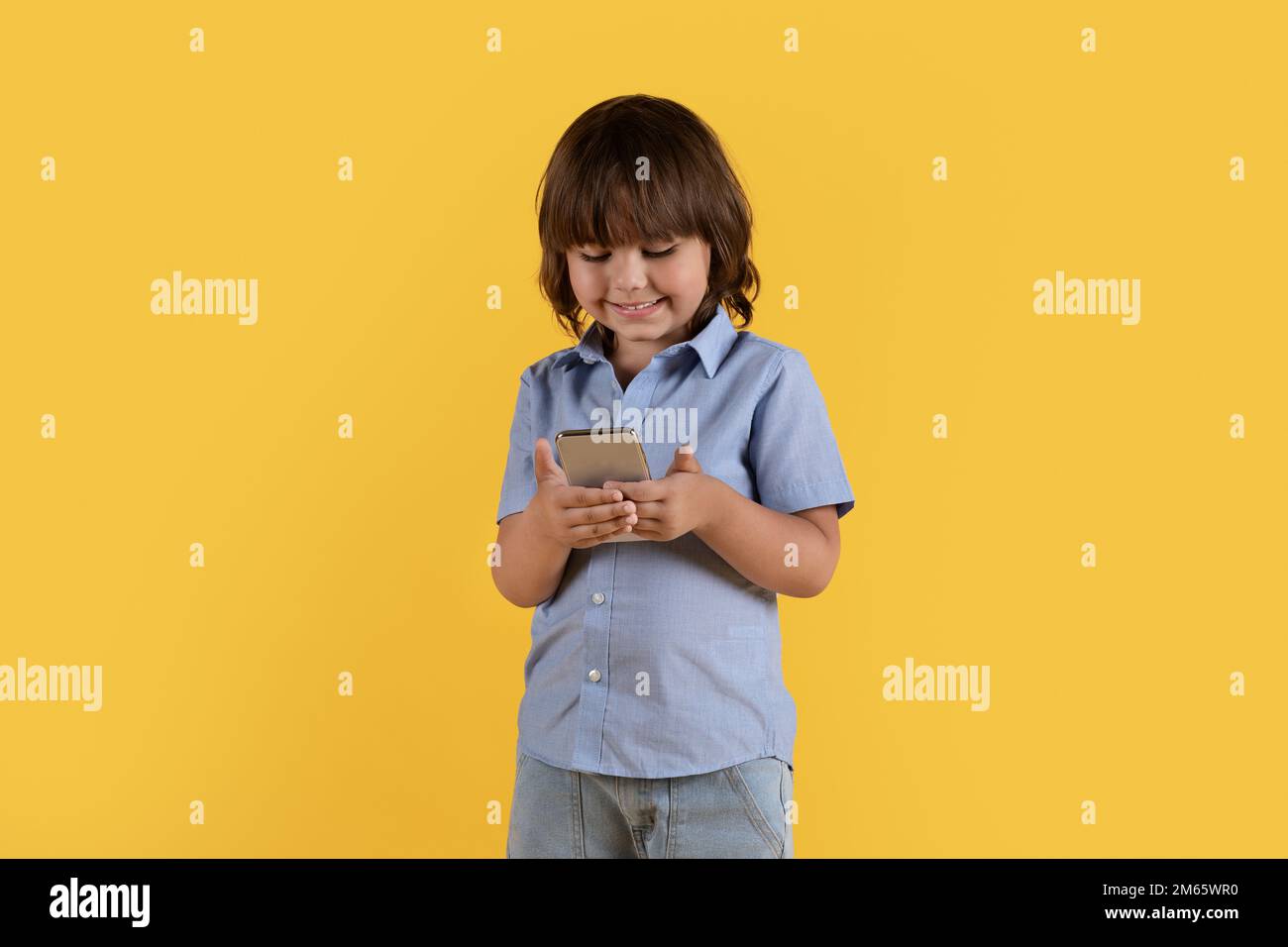 Great app for kids. Interested little boy looking at smartphone screen ...