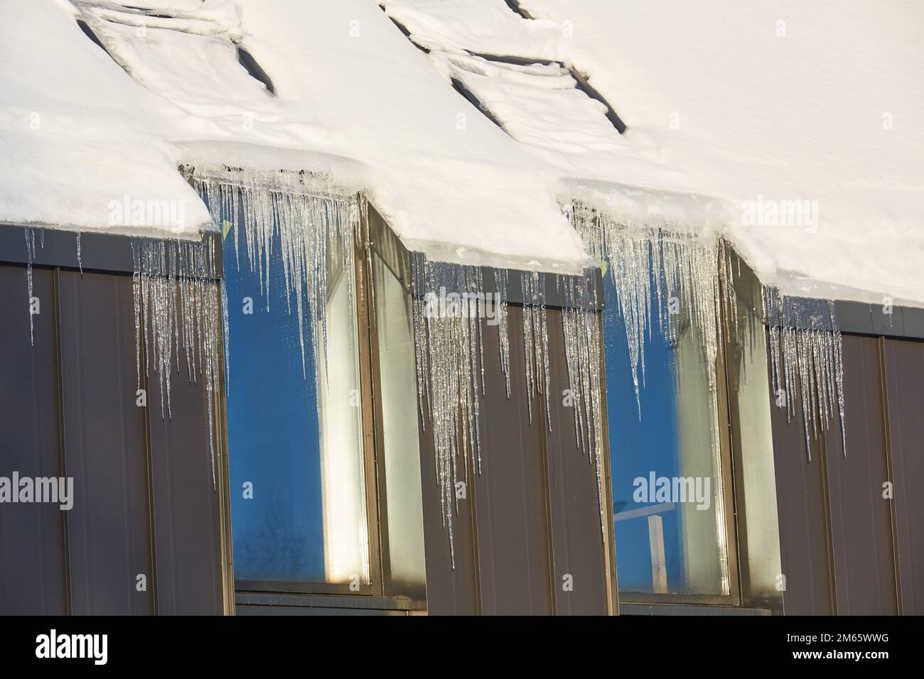 icicles on roof of modern house in sunny winter day. formation of ...