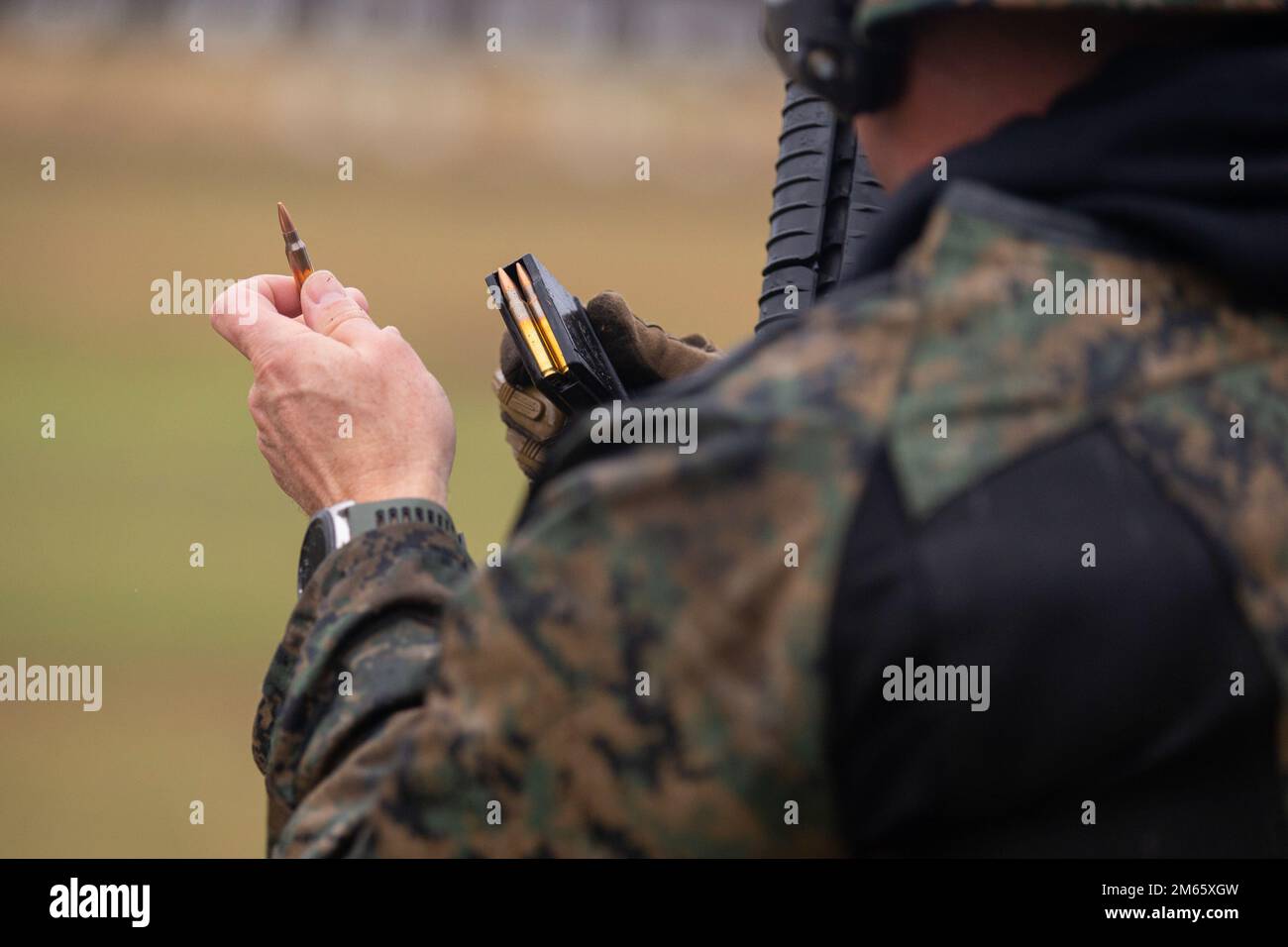 U.S. Marines loads ammunition into a magazine during the long range ...