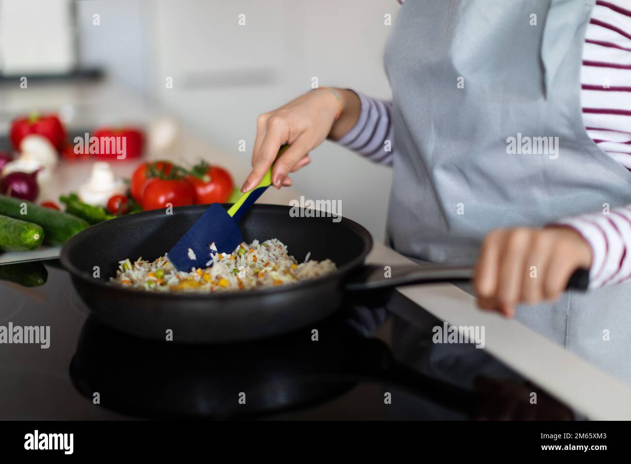 Female hands mixing rice with vegetables in frying pan Stock Photo - Alamy