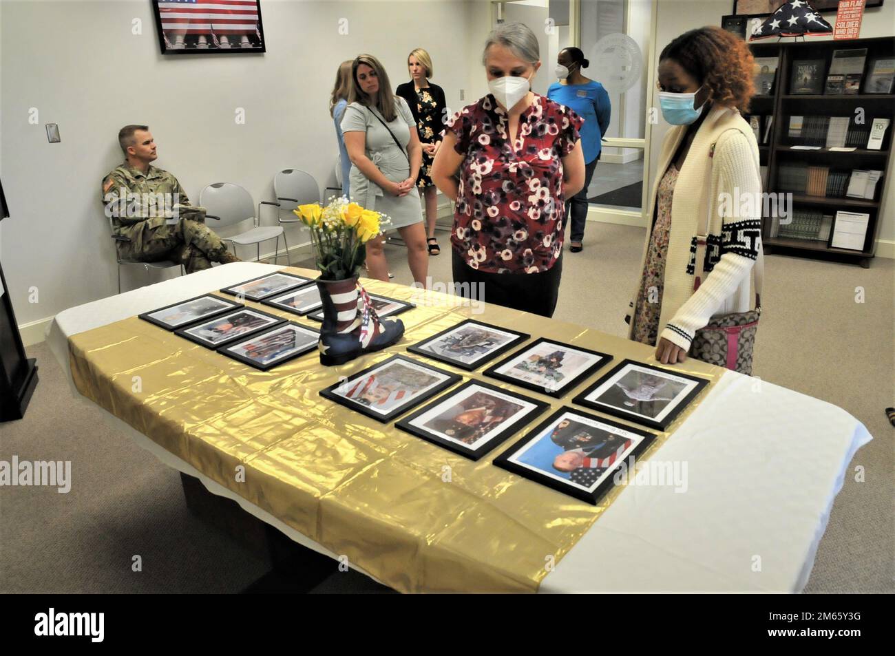 Family members examine framed photographs of fallen service members ...