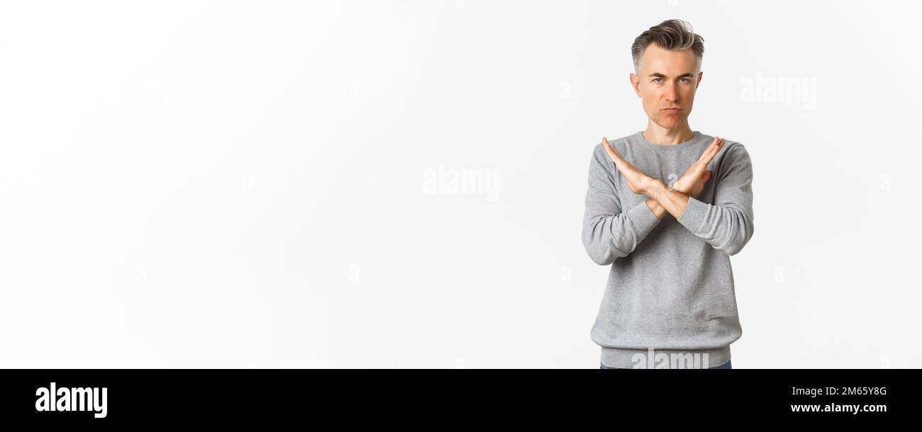 Image of angry middle-aged man looking serious, making cross gesture to ...