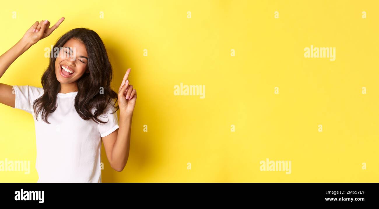 Portrait of cheerful african-american girl, dancing and singing ...