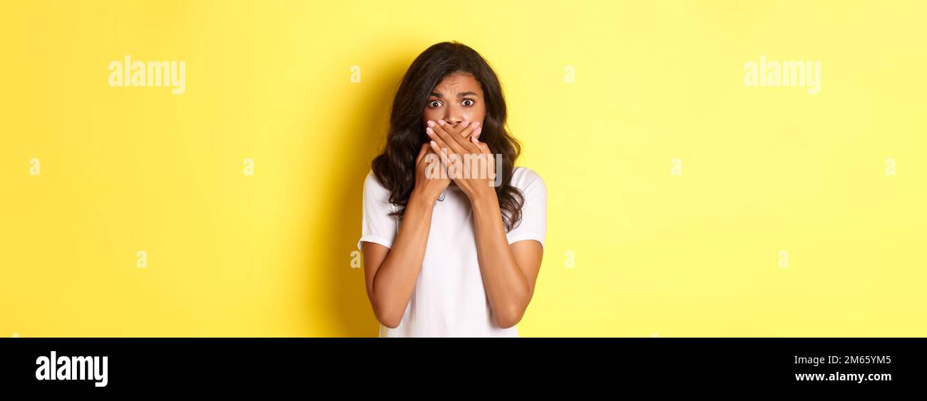 Portrait of timid and scared african-american girl, shut mouth and ...