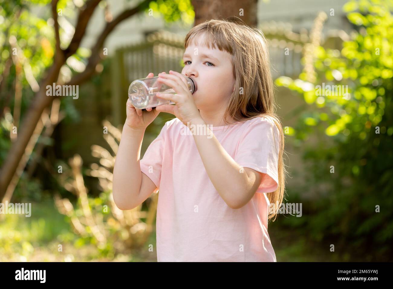 Elementary school age girl, child hydrating, drinking water from a ...
