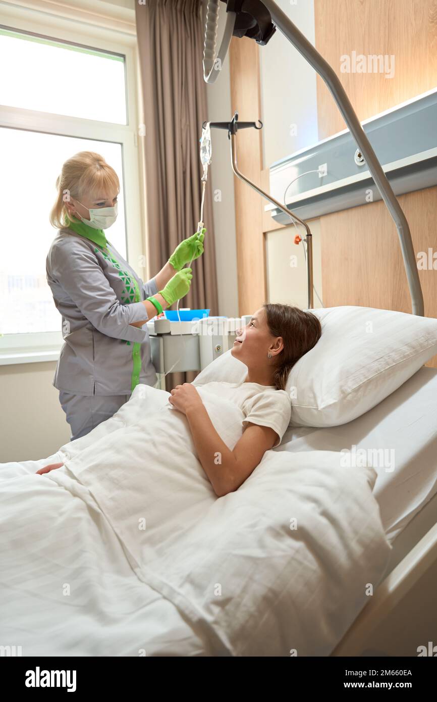 Medical worker controls the flow of medicine in a dropper Stock Photo ...