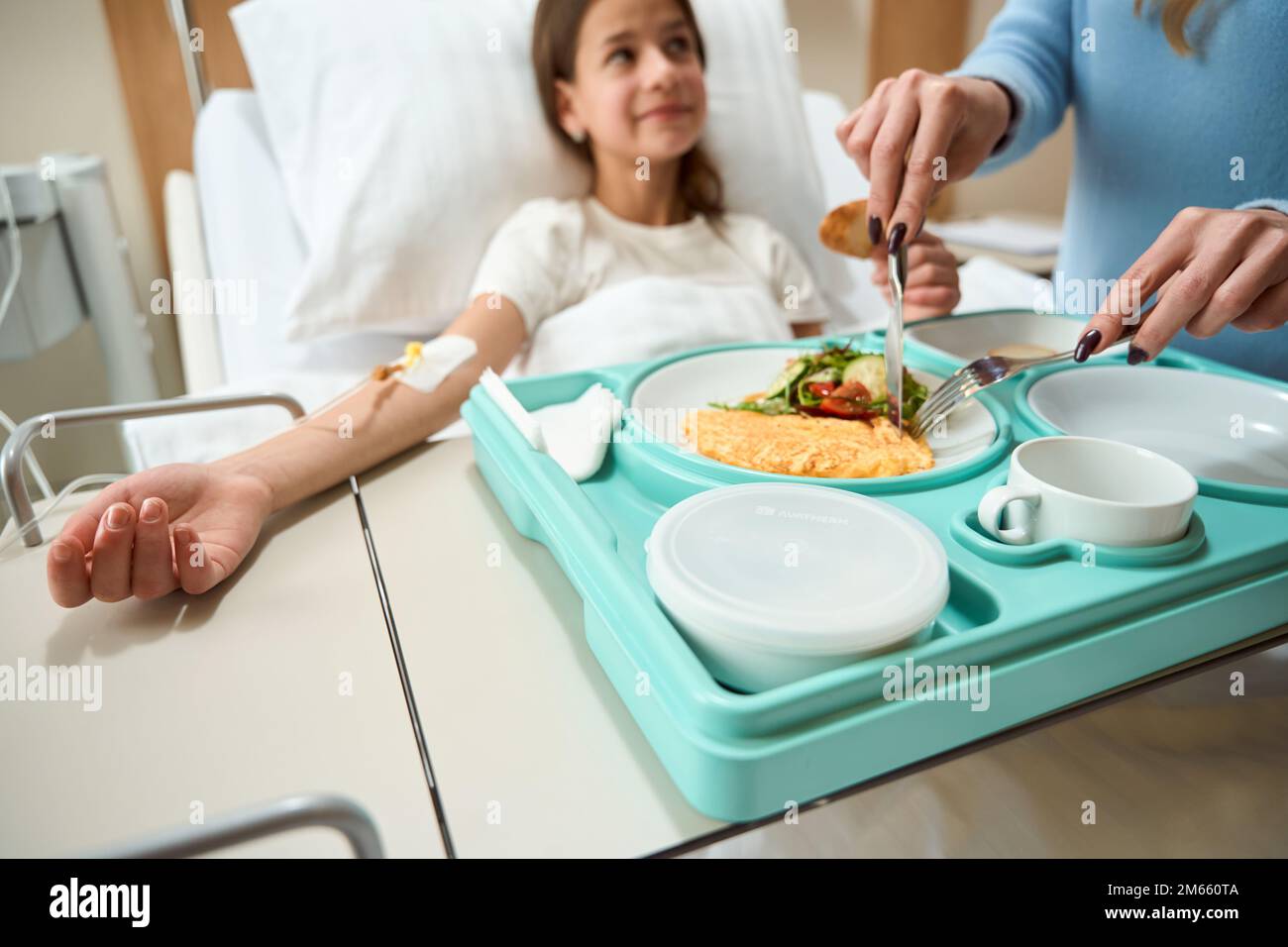 Recovering girl lies under a drip on a hospital bed Stock Photo - Alamy