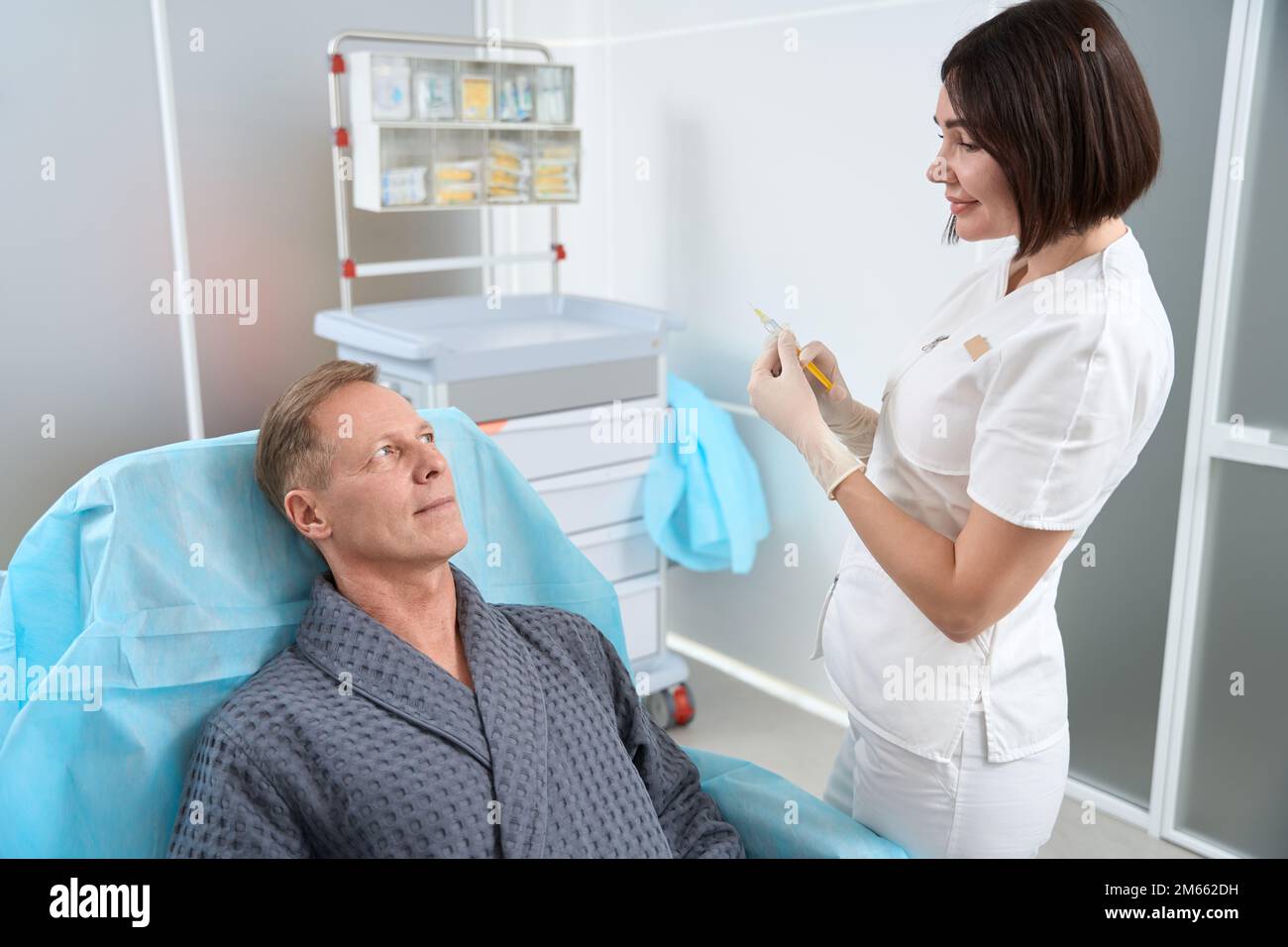 Certified doctor preparing patient for injection at modern clinic Stock ...