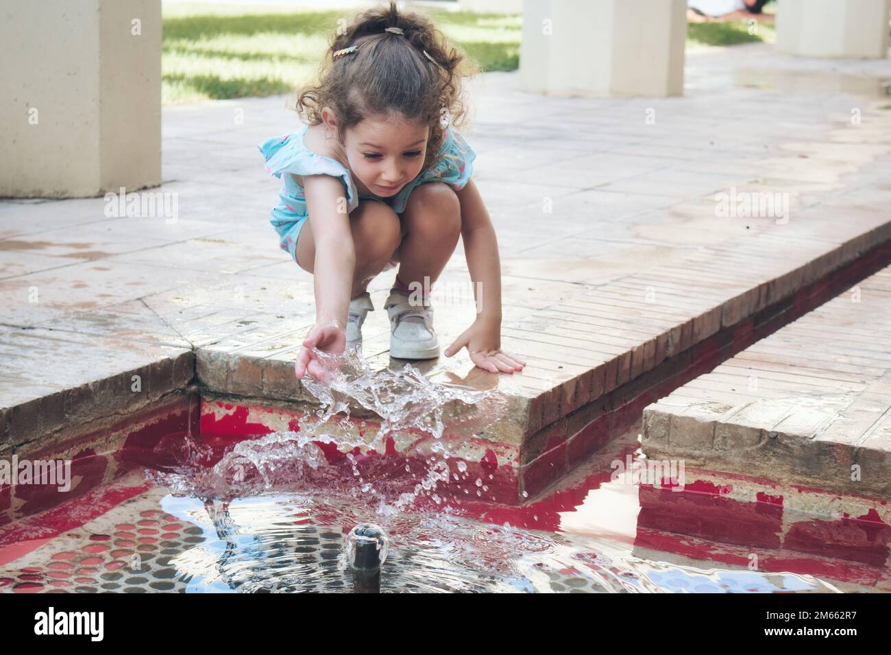 Girl playing in water fountain hi-res stock photography and images - Alamy