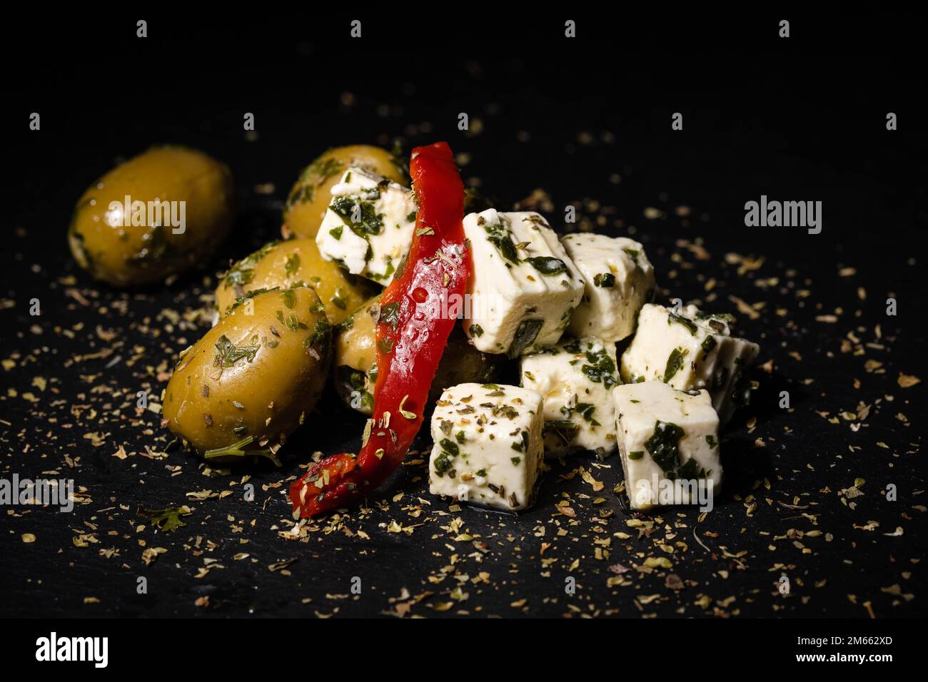 olives and feta with herbs and oil on black background Stock Photo - Alamy