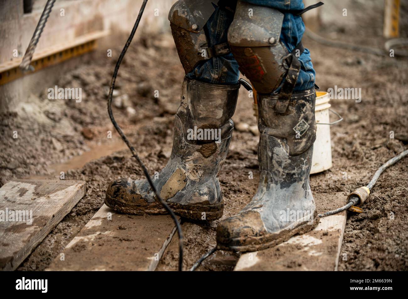 Jeremy Clevenger, a carpenter, drills holes to prepare a concrete form ...