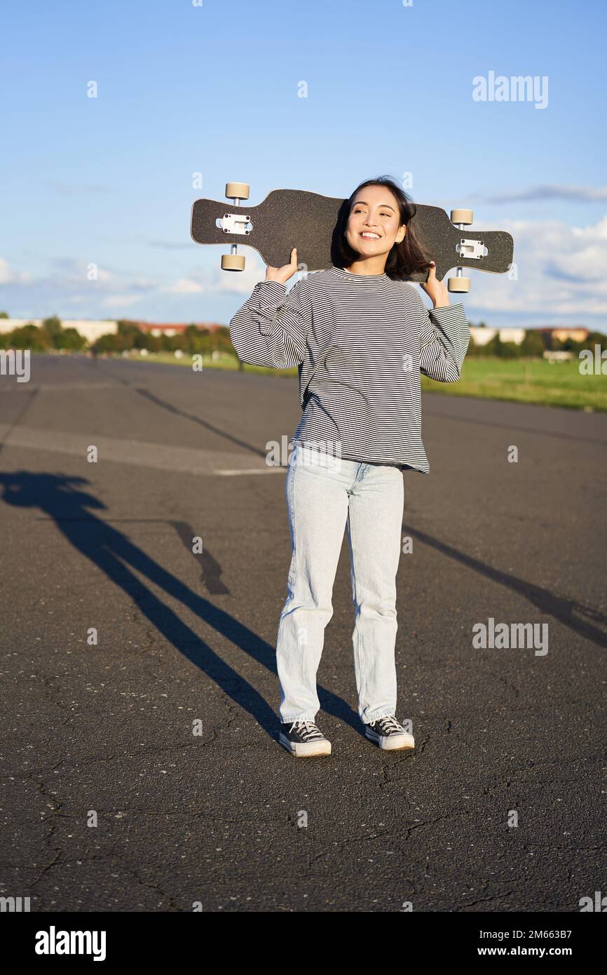 Lifestyle and people. Young asian girl posing with longboard, skating ...