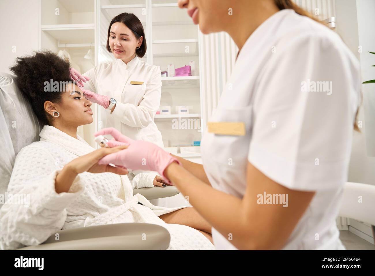 Cosmetologist consulting client during beauty injections in salon Stock ...